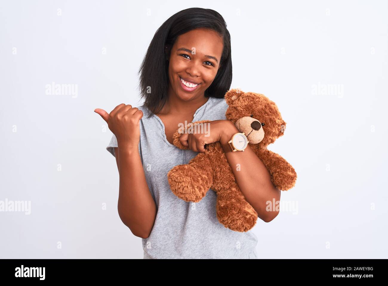 Young african american woman holding teddy bear over isolated ...