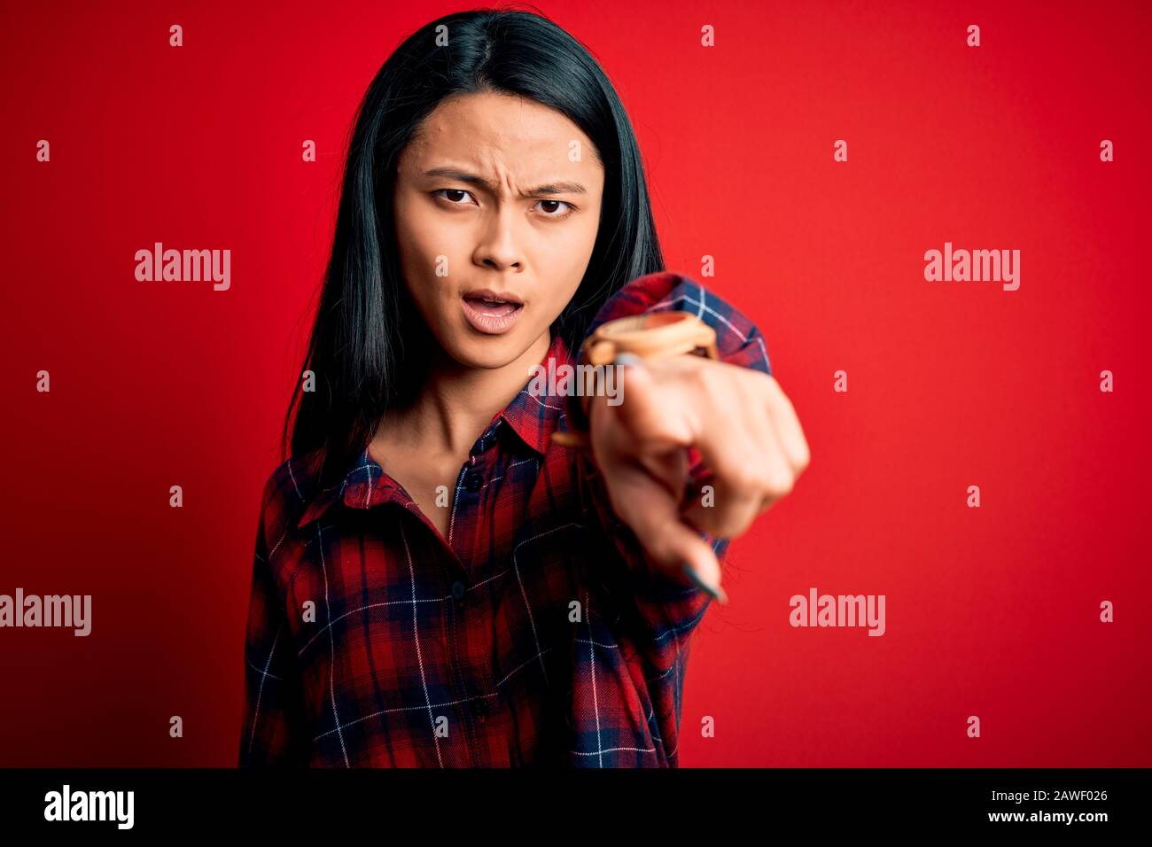 Young beautiful chinese woman wearing casual shirt over isolated red ...