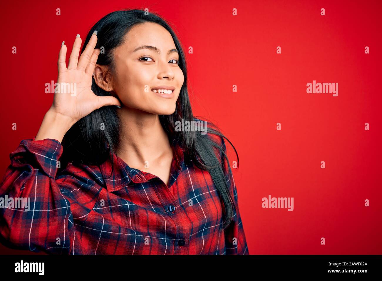 Young beautiful chinese woman wearing casual shirt over isolated red ...