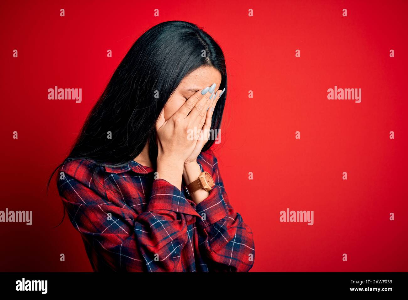 Young beautiful chinese woman wearing casual shirt over isolated red ...