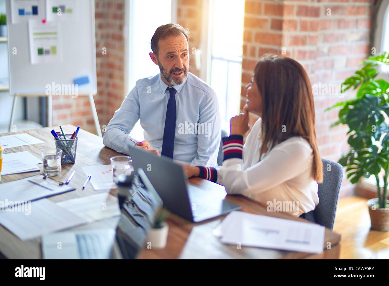 Two middle age business workers smiling happy and confident. Working ...