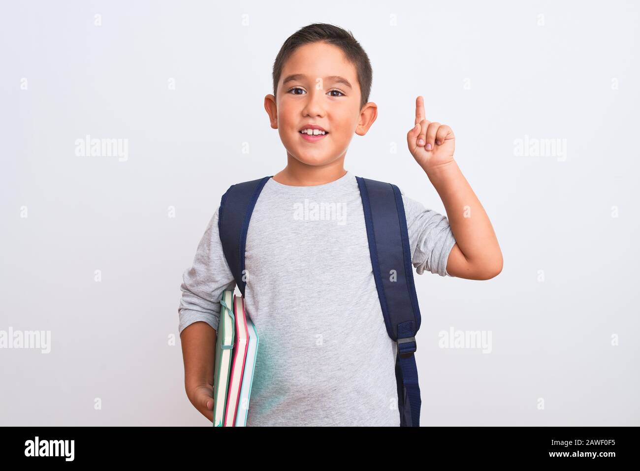 Beautiful student kid boy wearing backpack holding books over isolated ...