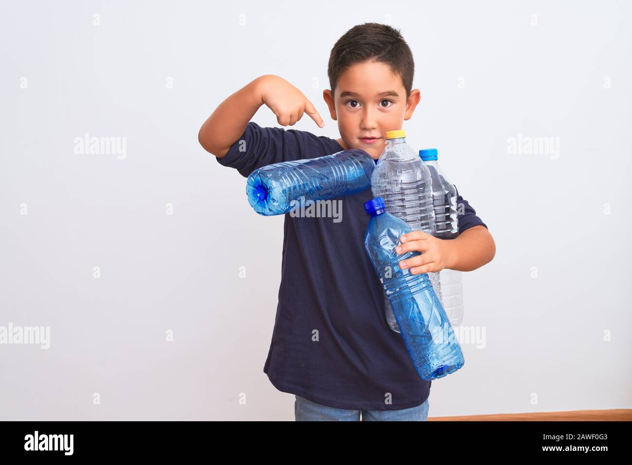Beautiful kid boy recycling plastic bottles standing over isolated ...