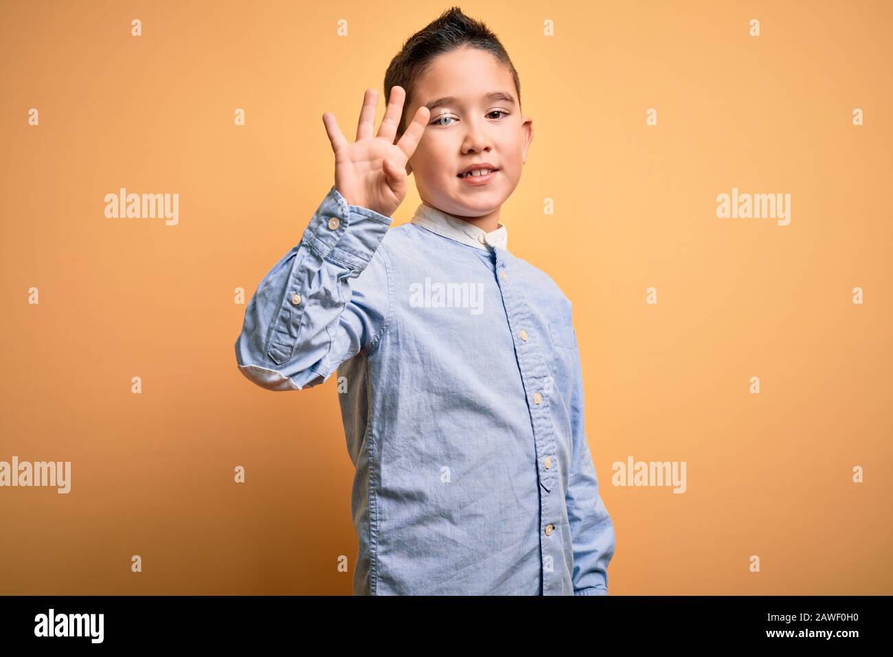 Young little boy kid wearing elegant shirt standing over yellow ...