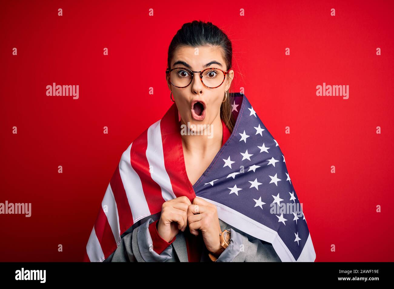 Young beautiful brunette patriotic woman wearing usa flag celebrating ...