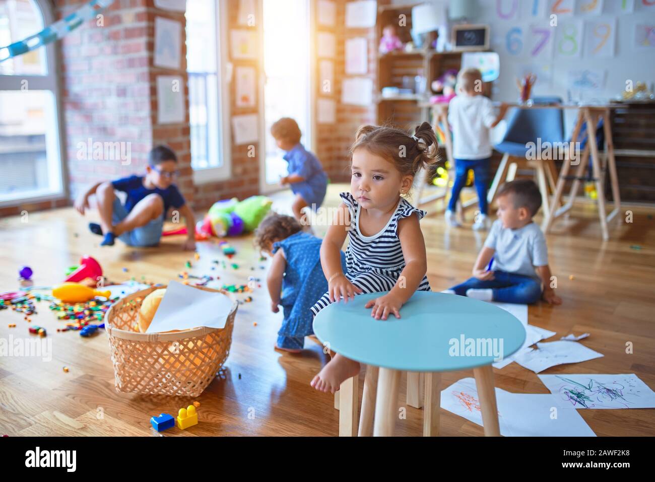 Adorable group of toddlers playing around lots of toys at kindergarten ...