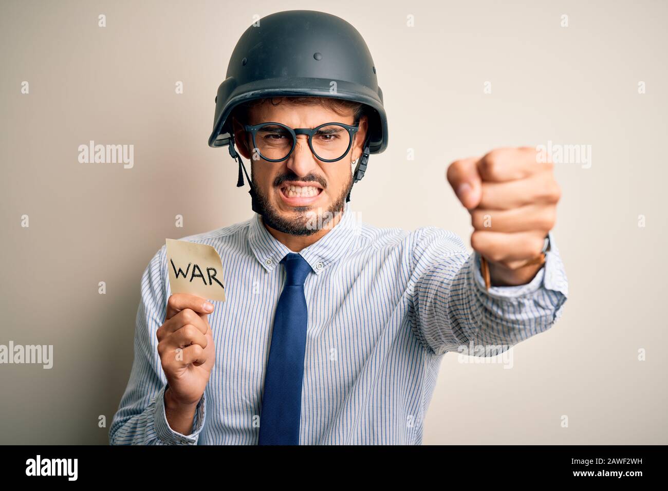 Young businessman with beard wearing helmet holding paper with war ...