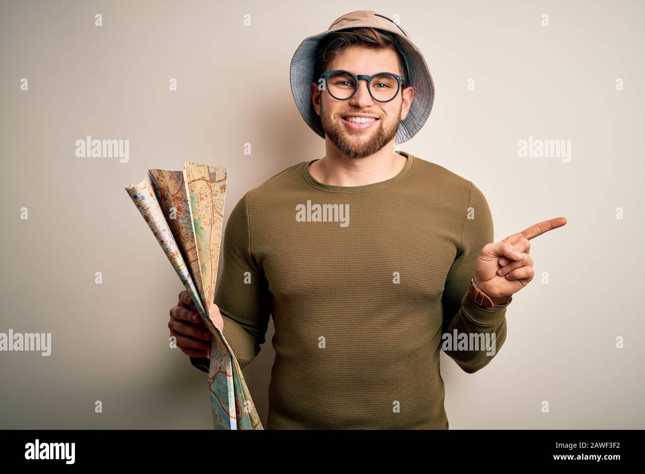Young blond explorer man with beard and blue eyes wearing glasses and ...