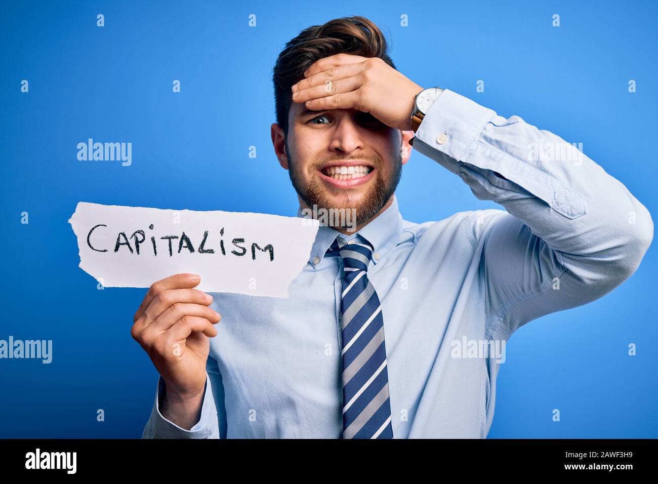 Young blond businessman with beard and blue eyes holding paper with ...