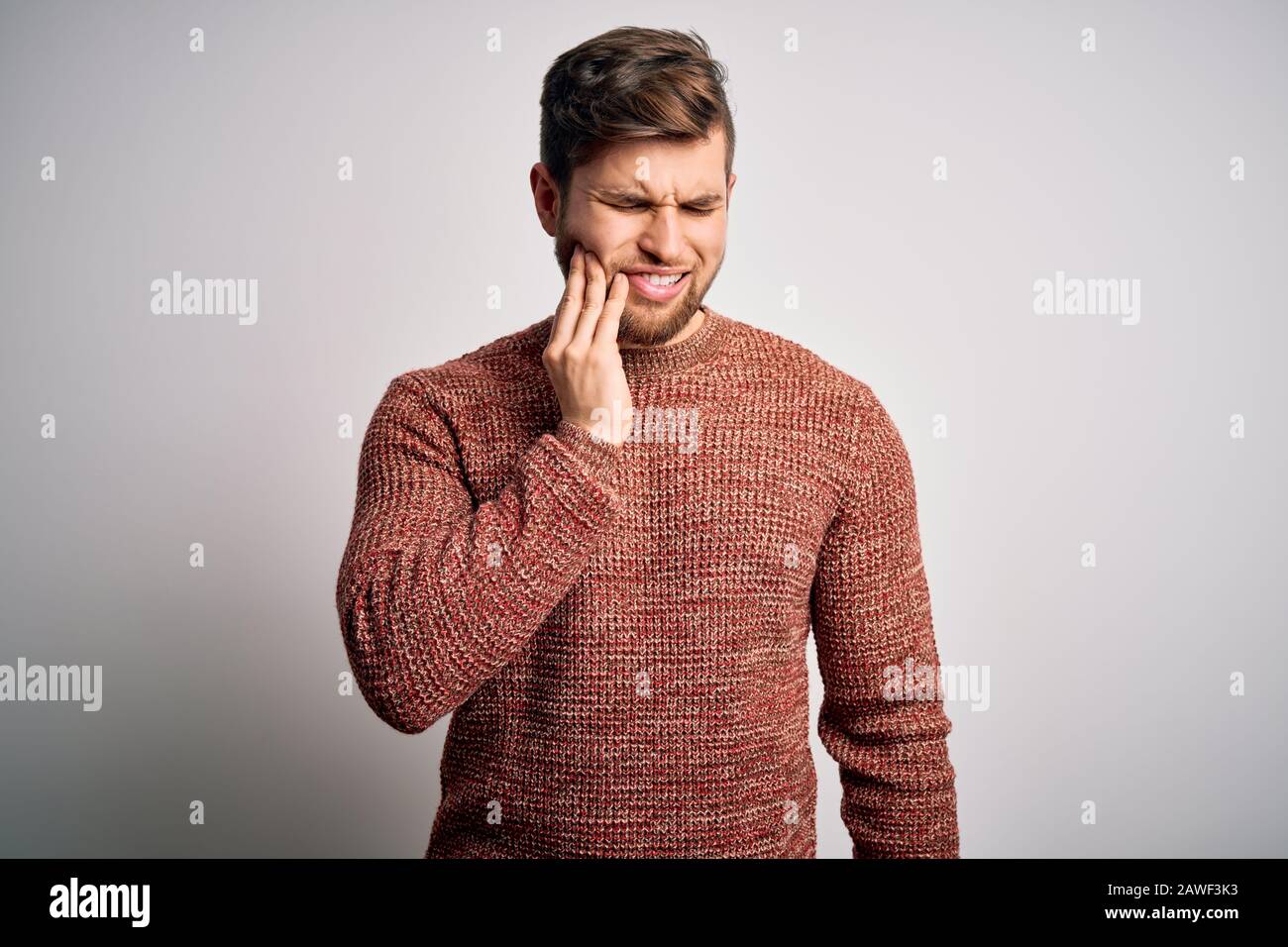 Young blond man with beard and blue eyes wearing casual sweater over ...