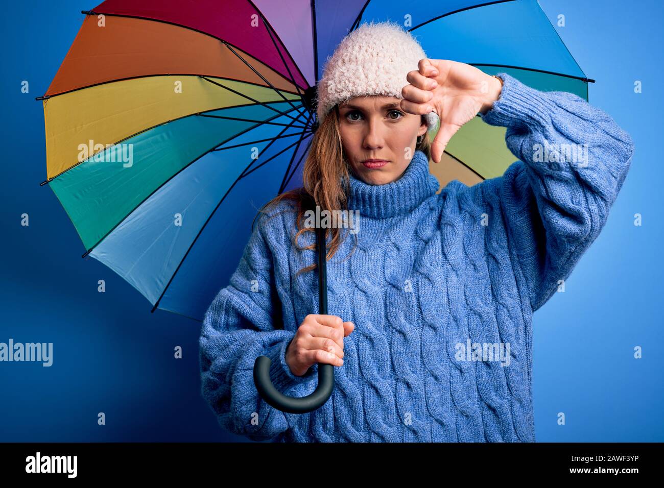 Young beautiful blonde woman holding colorful umbrella over isolated ...