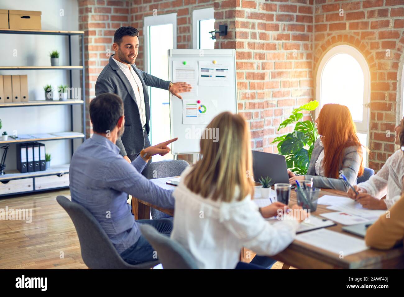 Group of business workers working together in a meeting. One of them ...