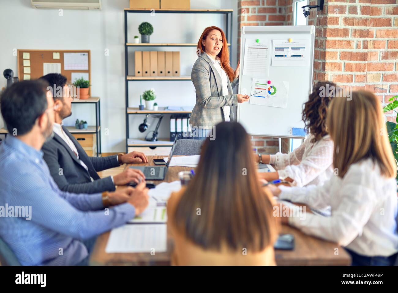 Group of business workers working together in a meeting. One of them ...