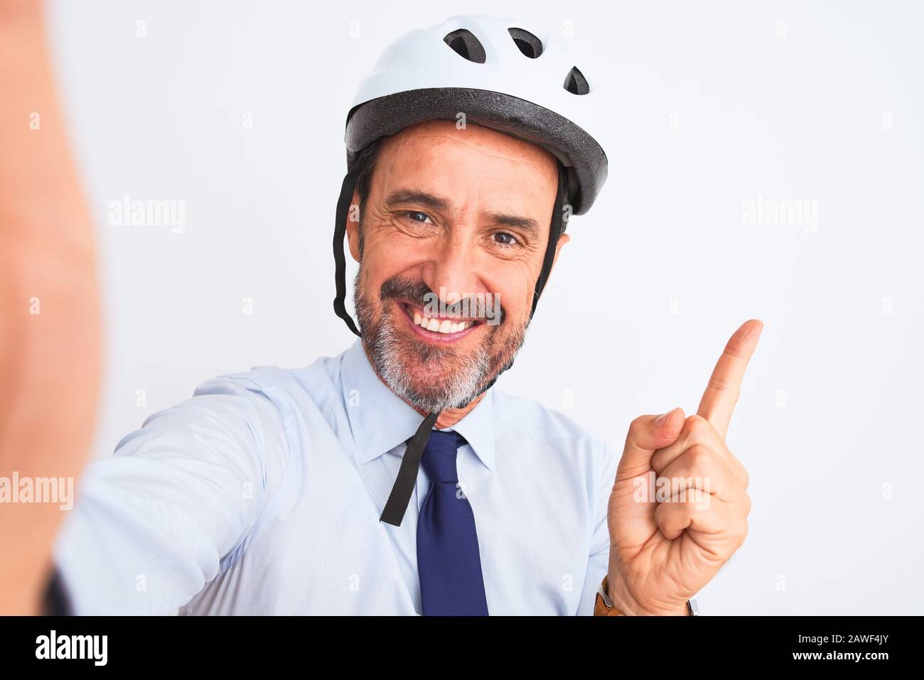 Middle age businessman wearing bike helmet make selfie over isolated ...