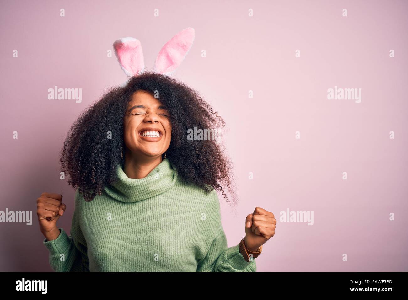 Young african american woman with afro hair wearing easter rabbit ears ...