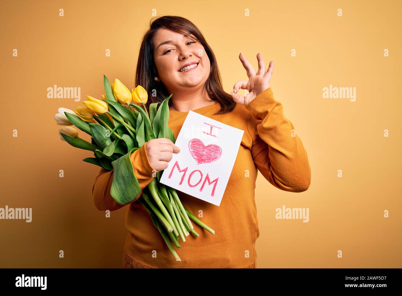 Young beautiful plus size woman celebrating mothers day holding love ...