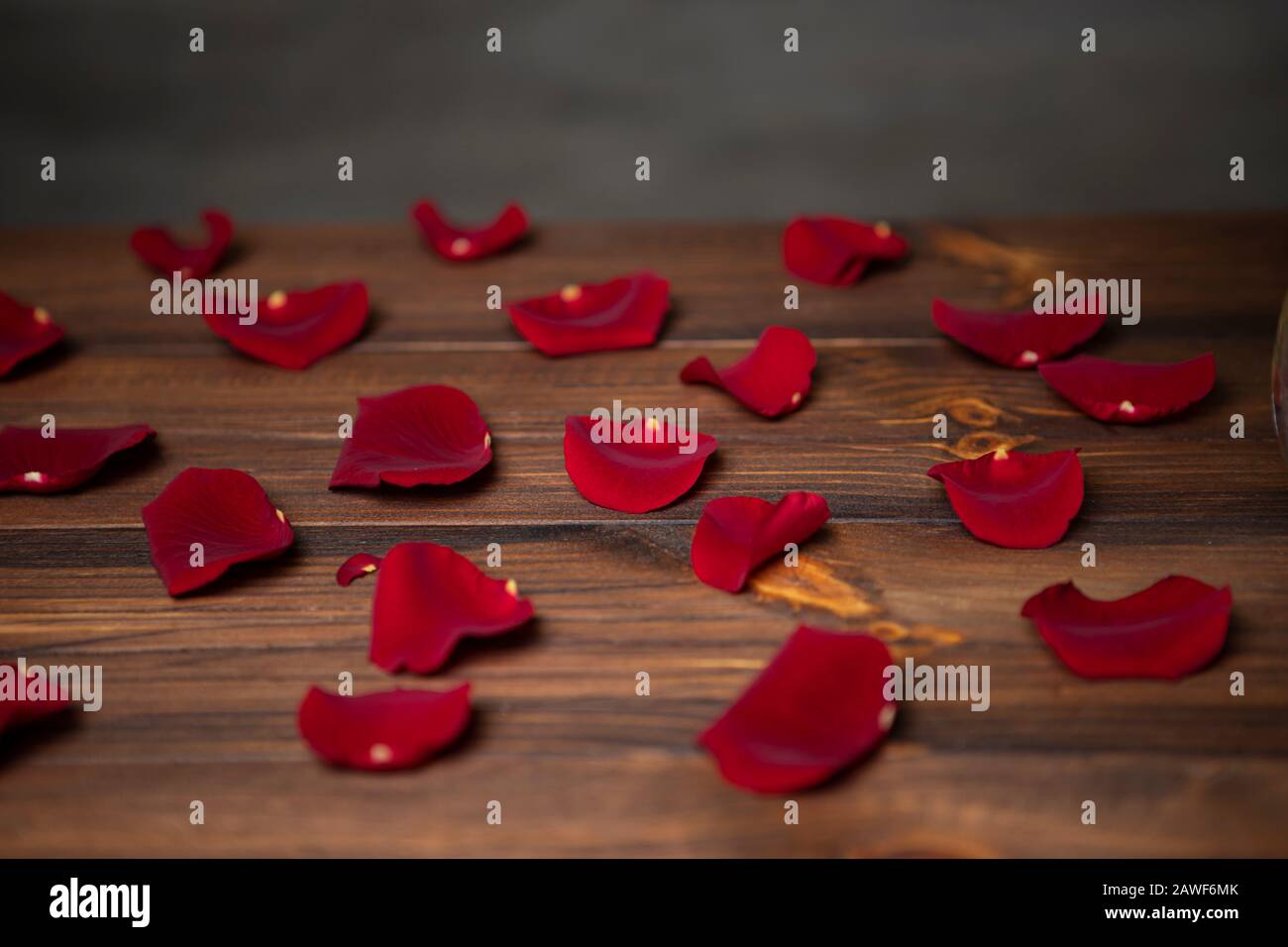 Fresh Red roses petals on the moody wooden background Stock Photo - Alamy