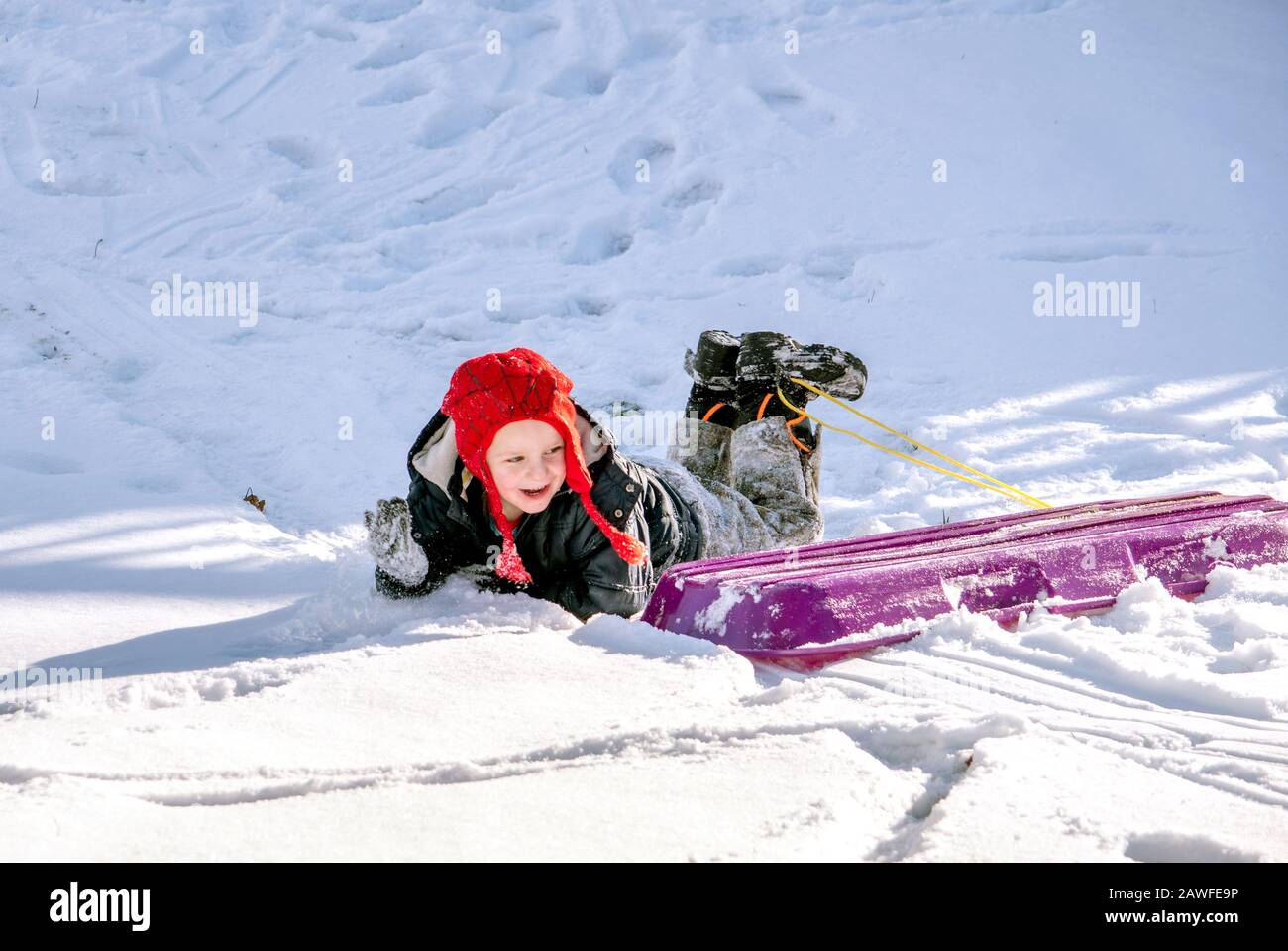 Boy sledding down hill hi-res stock photography and images - Alamy