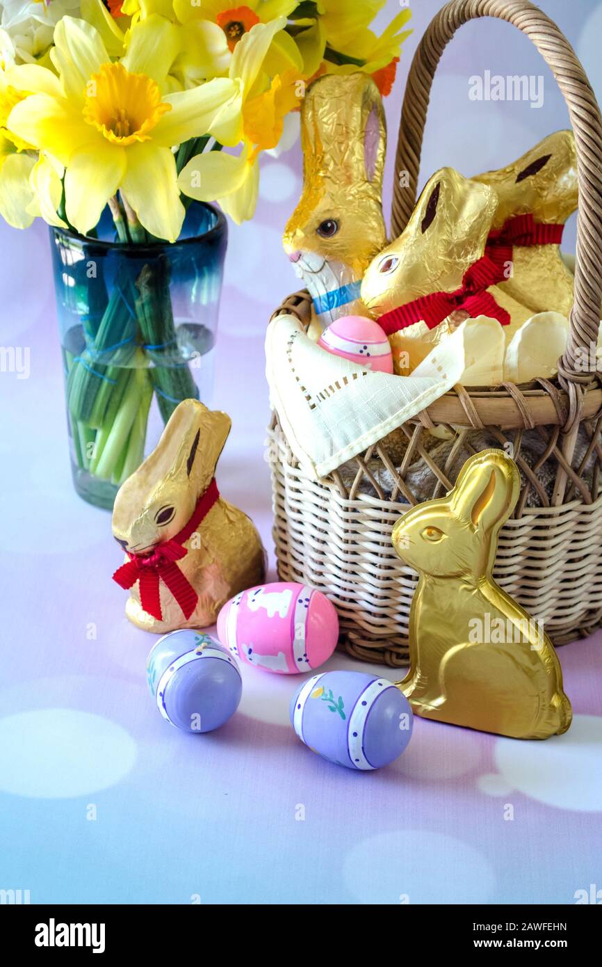 Chocolate rabbits wrapped in gold foil, and colorful easter eggs, make ...