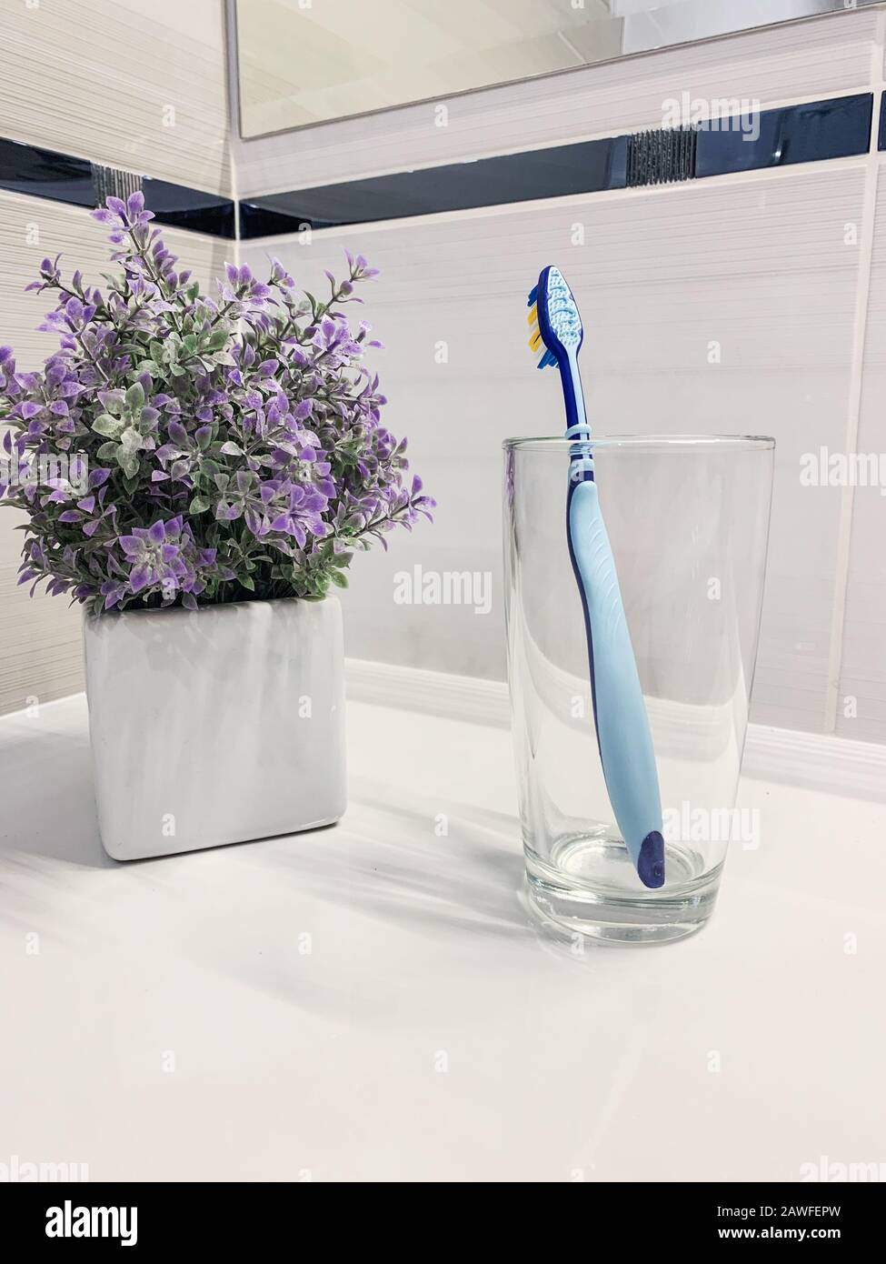 Blue toothbrush in glass for brushing the teeth Stock Photo - Alamy