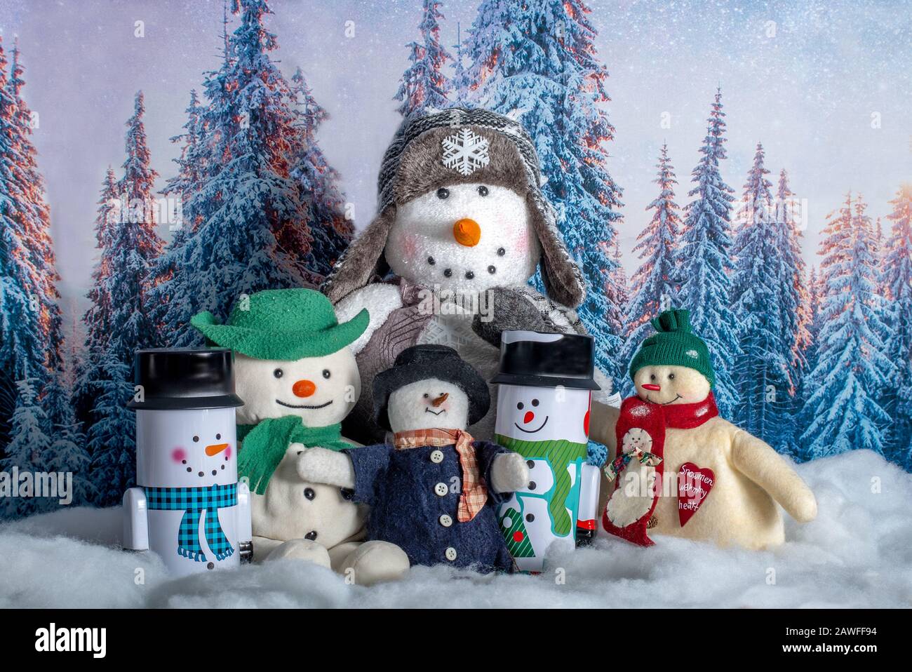A variety of whimsical snowmen pose for a group photo against snowy ...