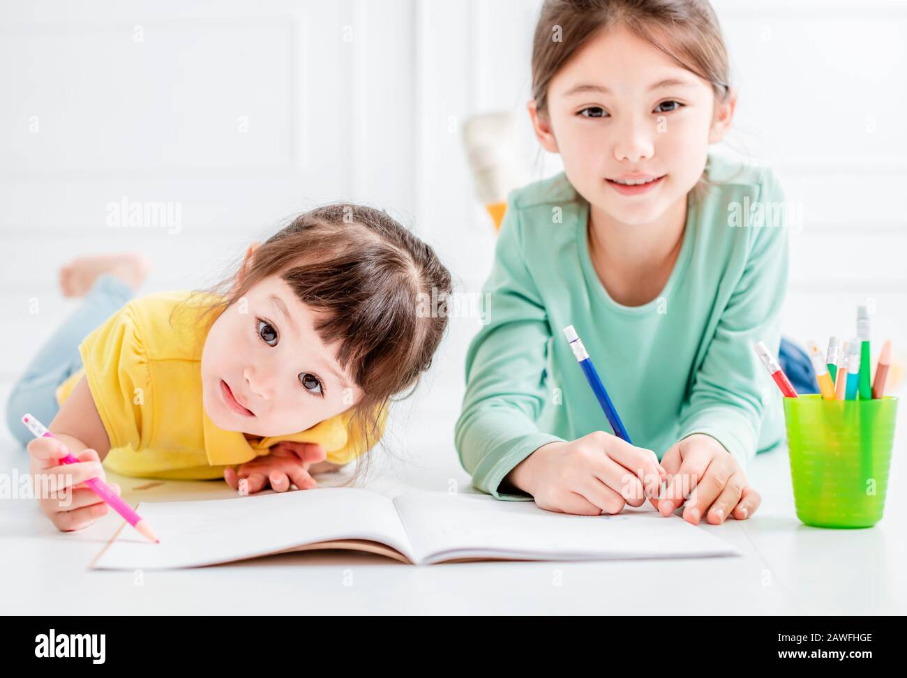 happy two little girl drawing and do homework on the flloor Stock Photo ...