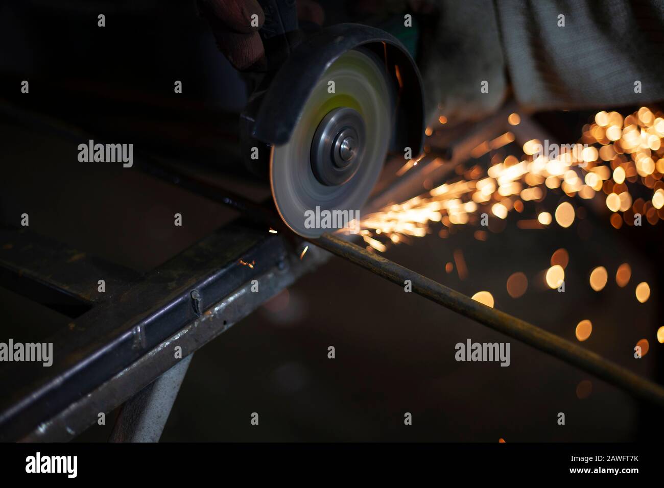 Metal processing in the workshop. Grinding metal. The worker makes the ...