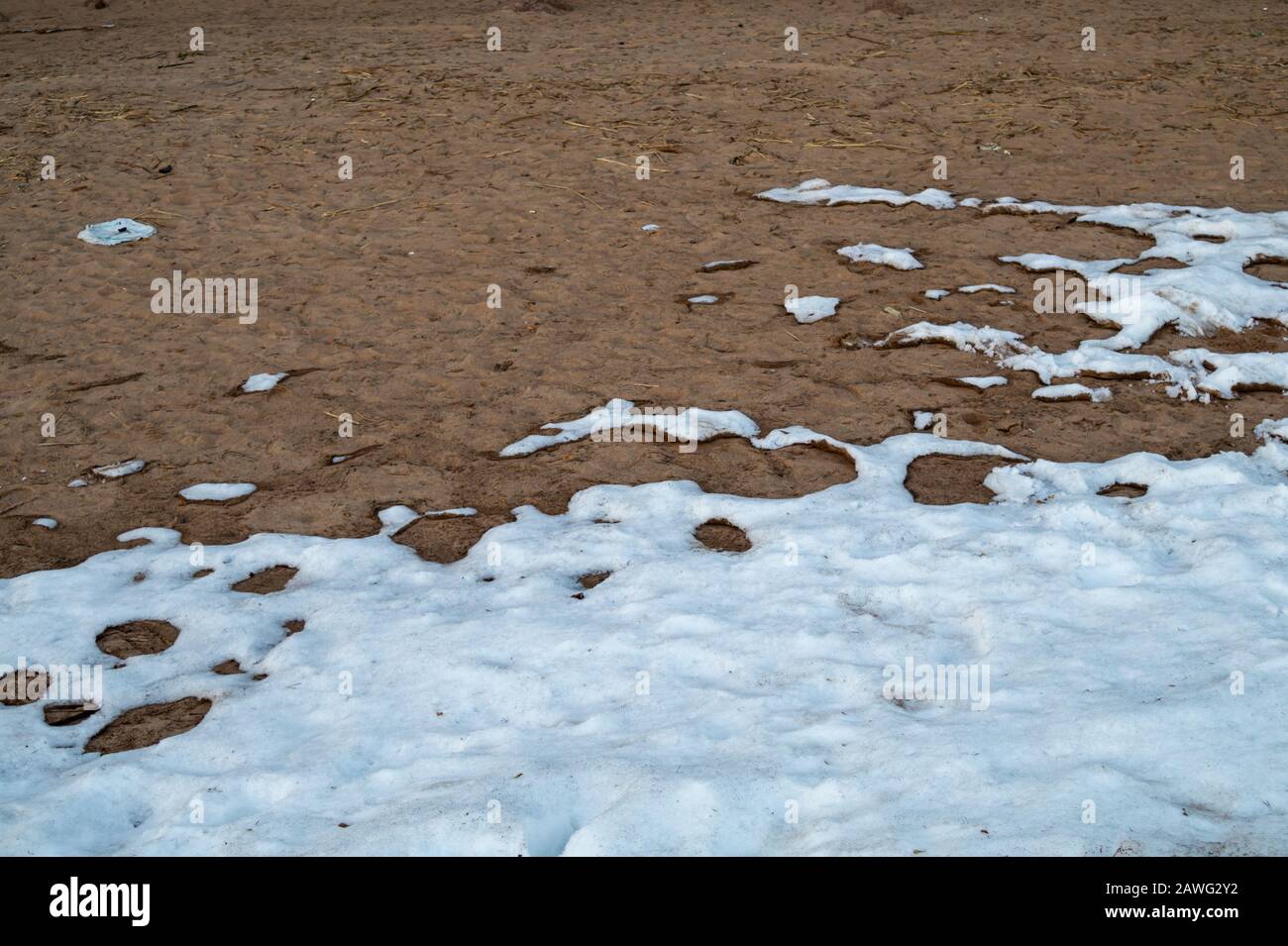 Snow covered sand. melting snow on the ground Stock Photo - Alamy