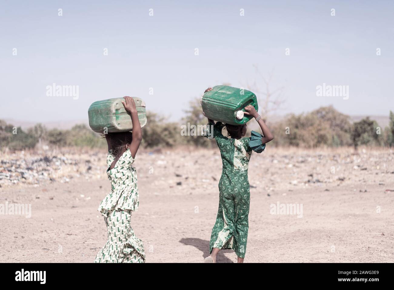 Tiny Native African Young Woman Gathering Pure Water in a typical ...