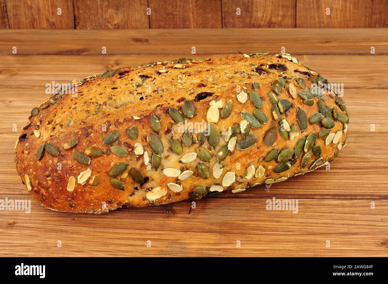 Rustic pumpkin seed covered crusty bloomer loaf on a wooden background ...
