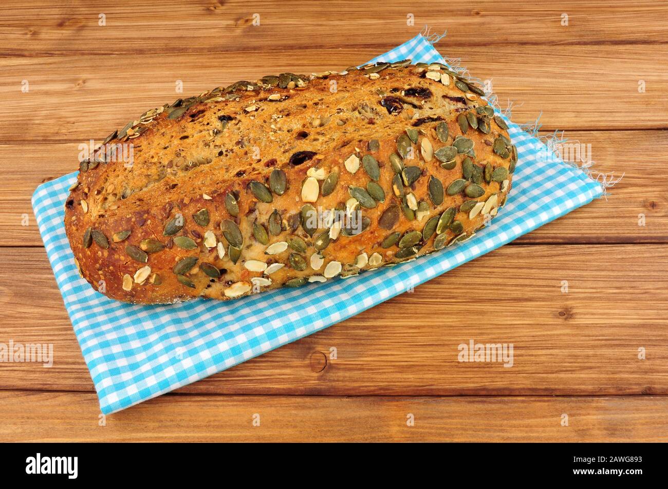 Rustic pumpkin seed covered crusty bloomer loaf on a wooden background ...