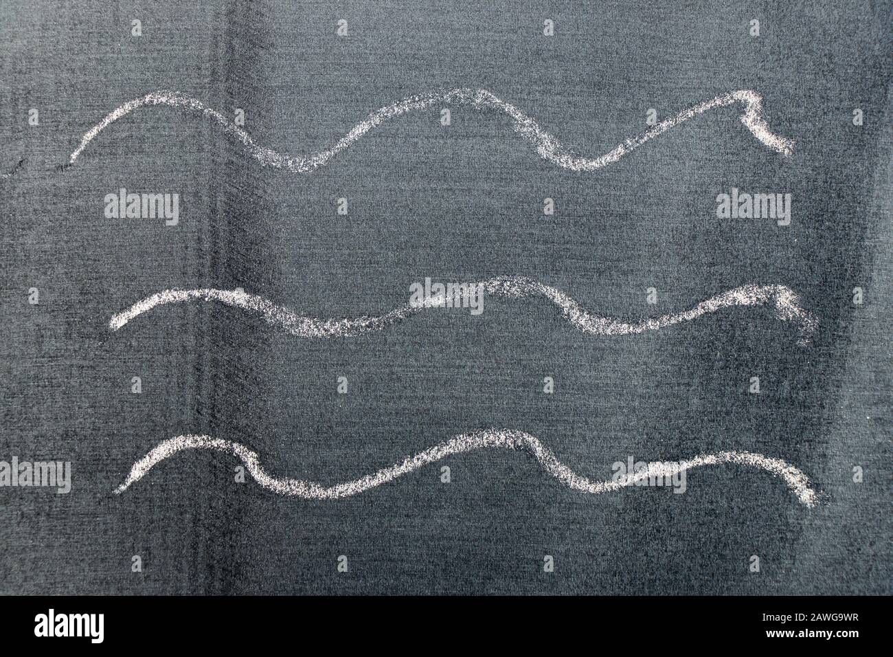 White color chalk hand drawing in set of curve or wavy line shape on ...