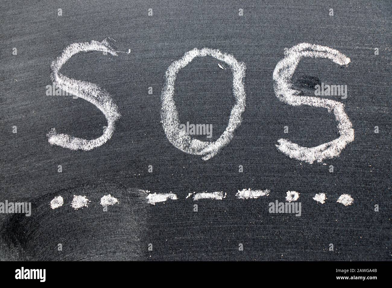 White color chalk hand drawing in SOS (abbreviation of save our soul ...