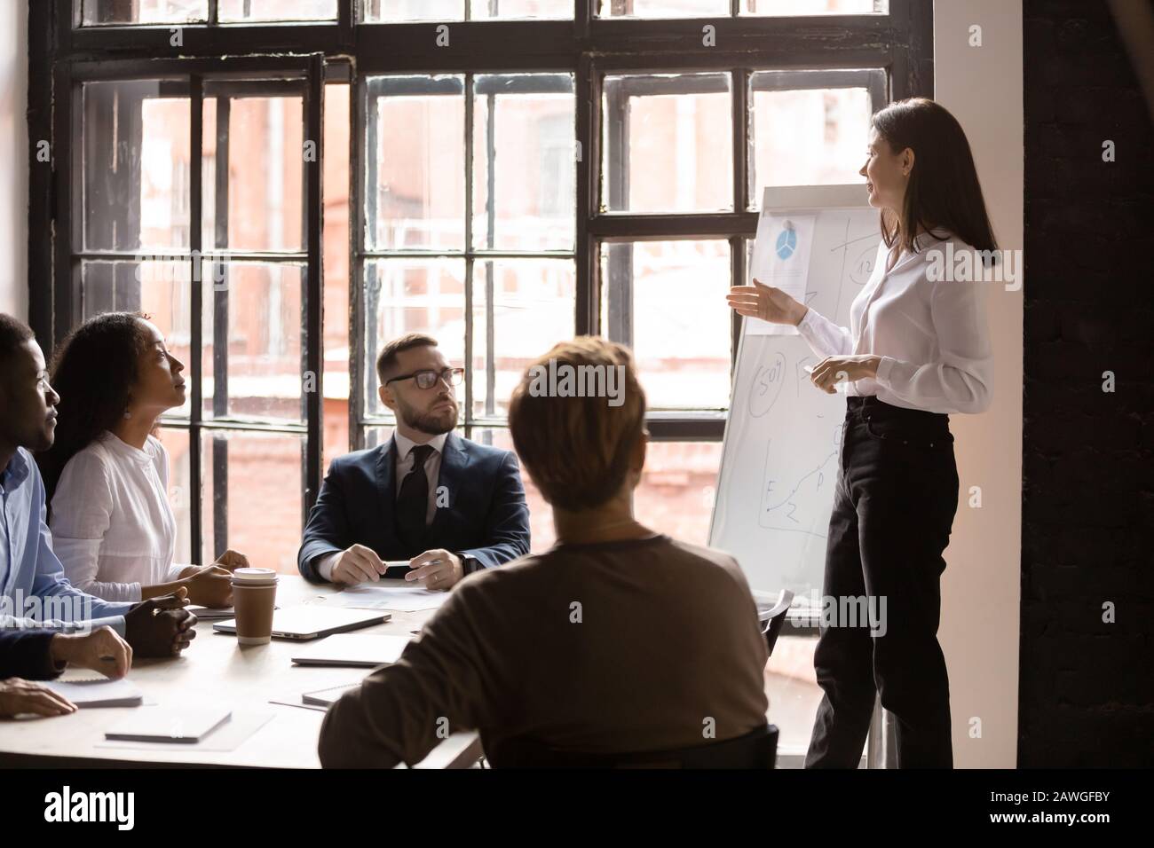 Audience listening female business trainer during corporate training in ...