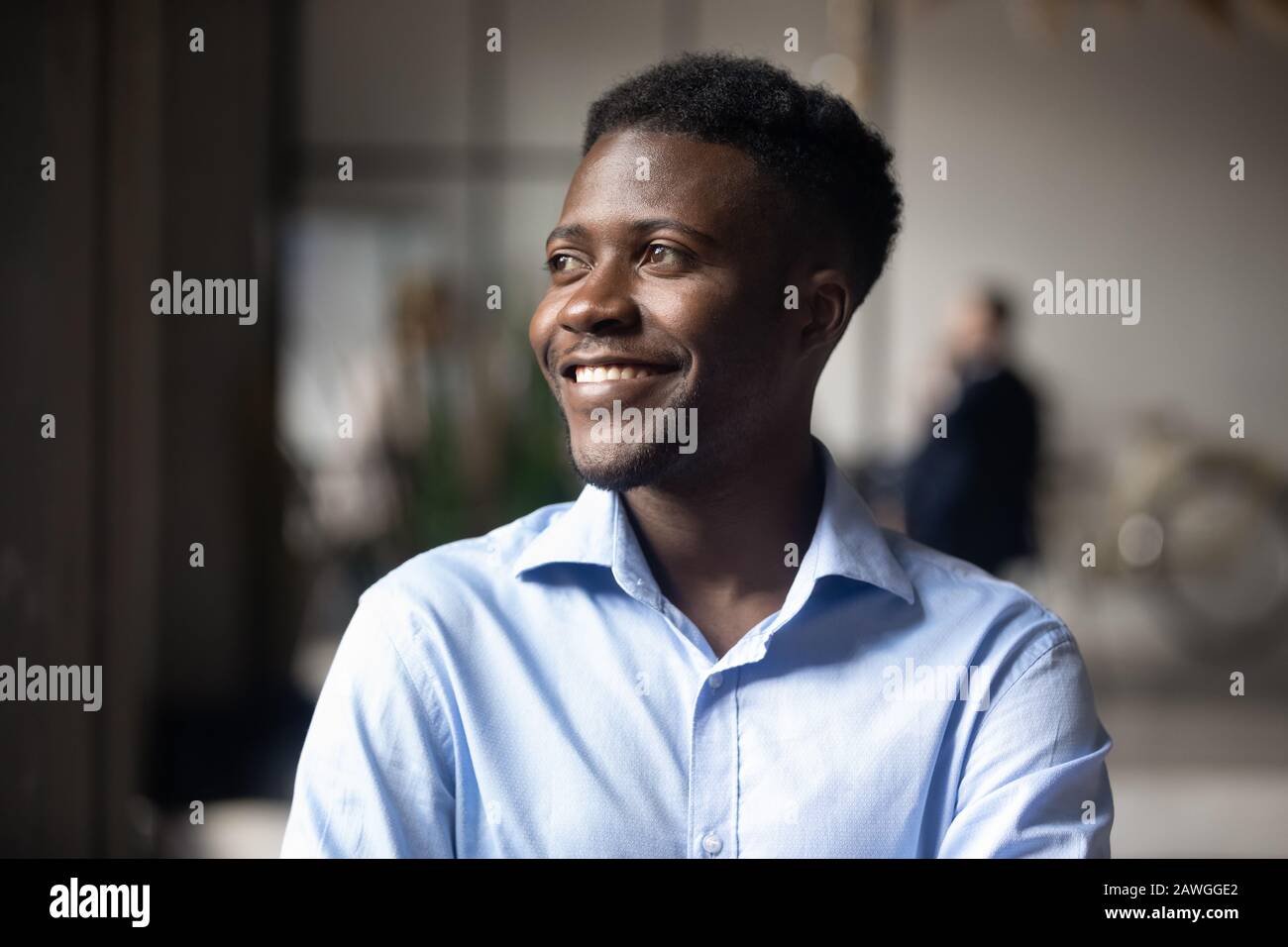Happy African ethnicity businessman standing in modern workspace feels ...