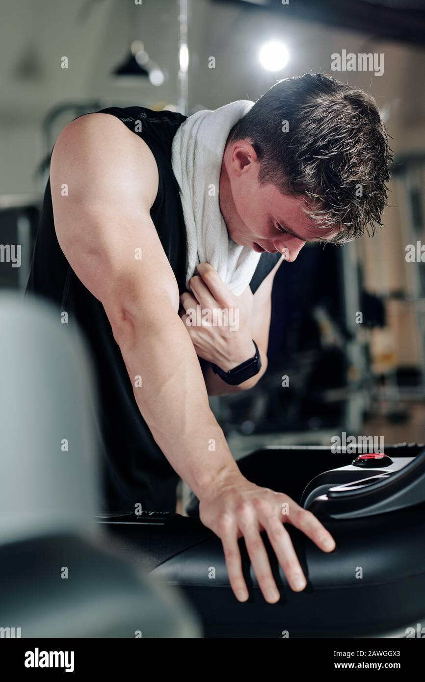 Sweaty fit young man exhausted after running on threadmill in gym Stock ...