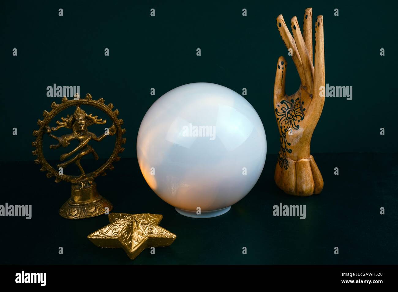esoteric still life with a crystal ball and wooden hand, statuette of ...