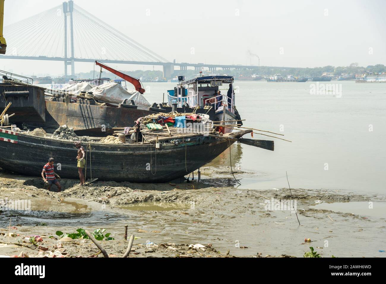 Indian workers digging Hooghly or Ganga river ground in the boat ...