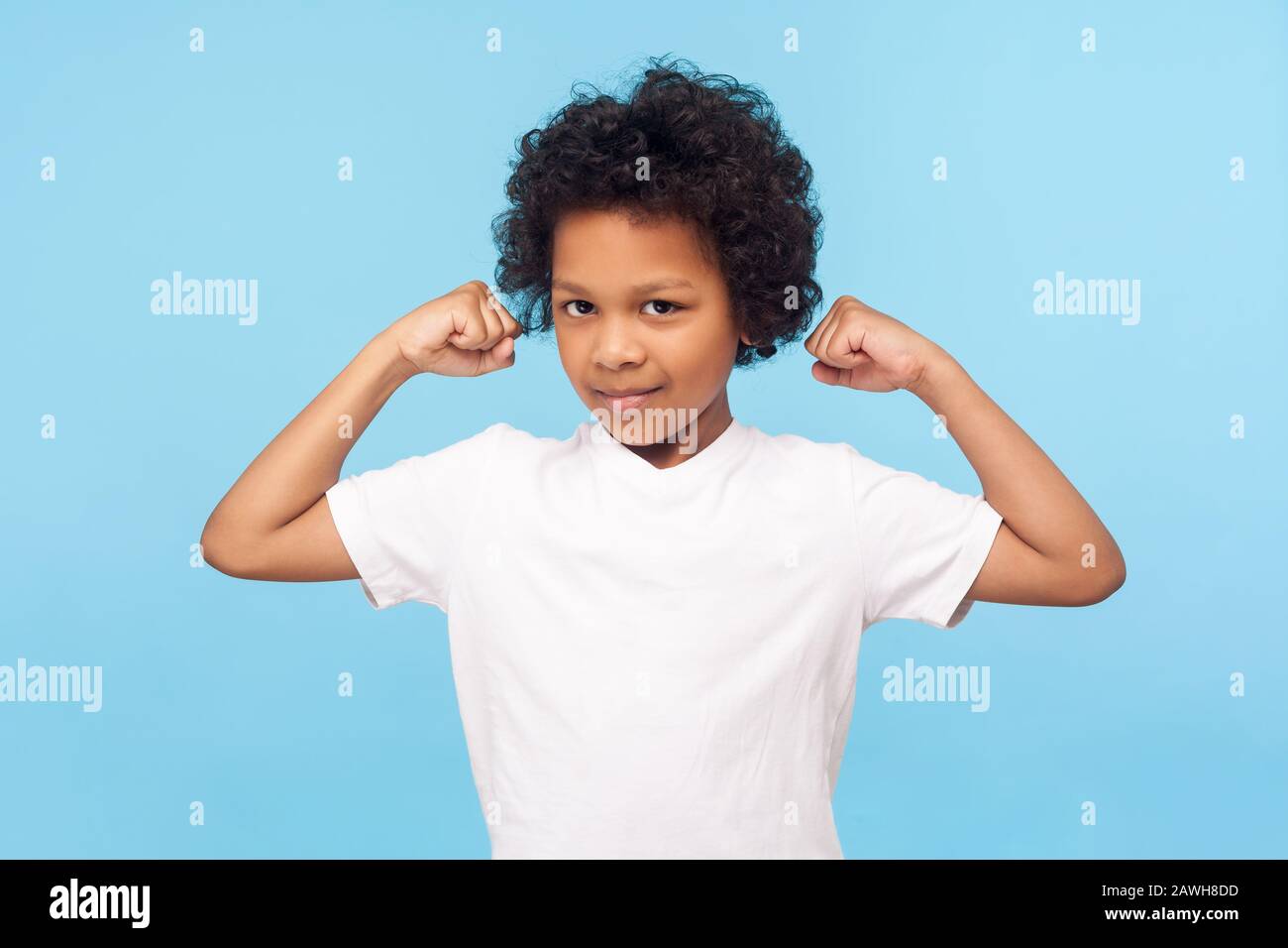 I'm strong. Portrait of adorable little boy in white T-shirt showing ...
