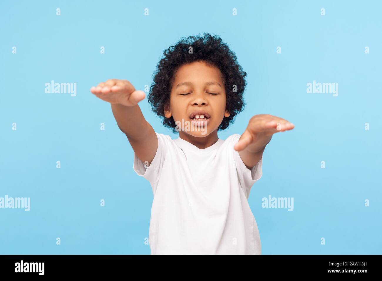 Portrait of blind little curly boy walking with closed eyes and ...