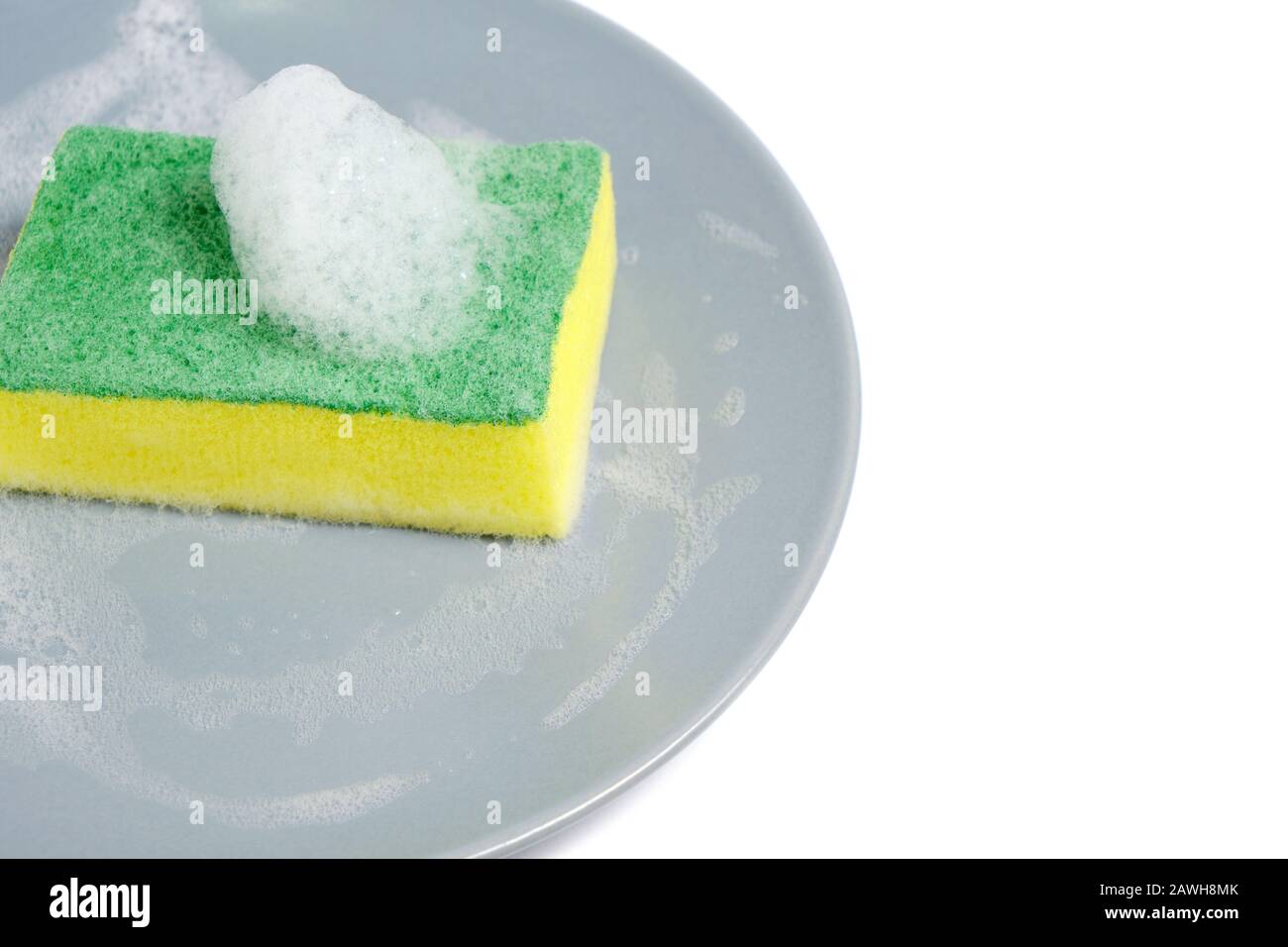 Foam sponge for washing dishes, dirty gray plate on a white background ...