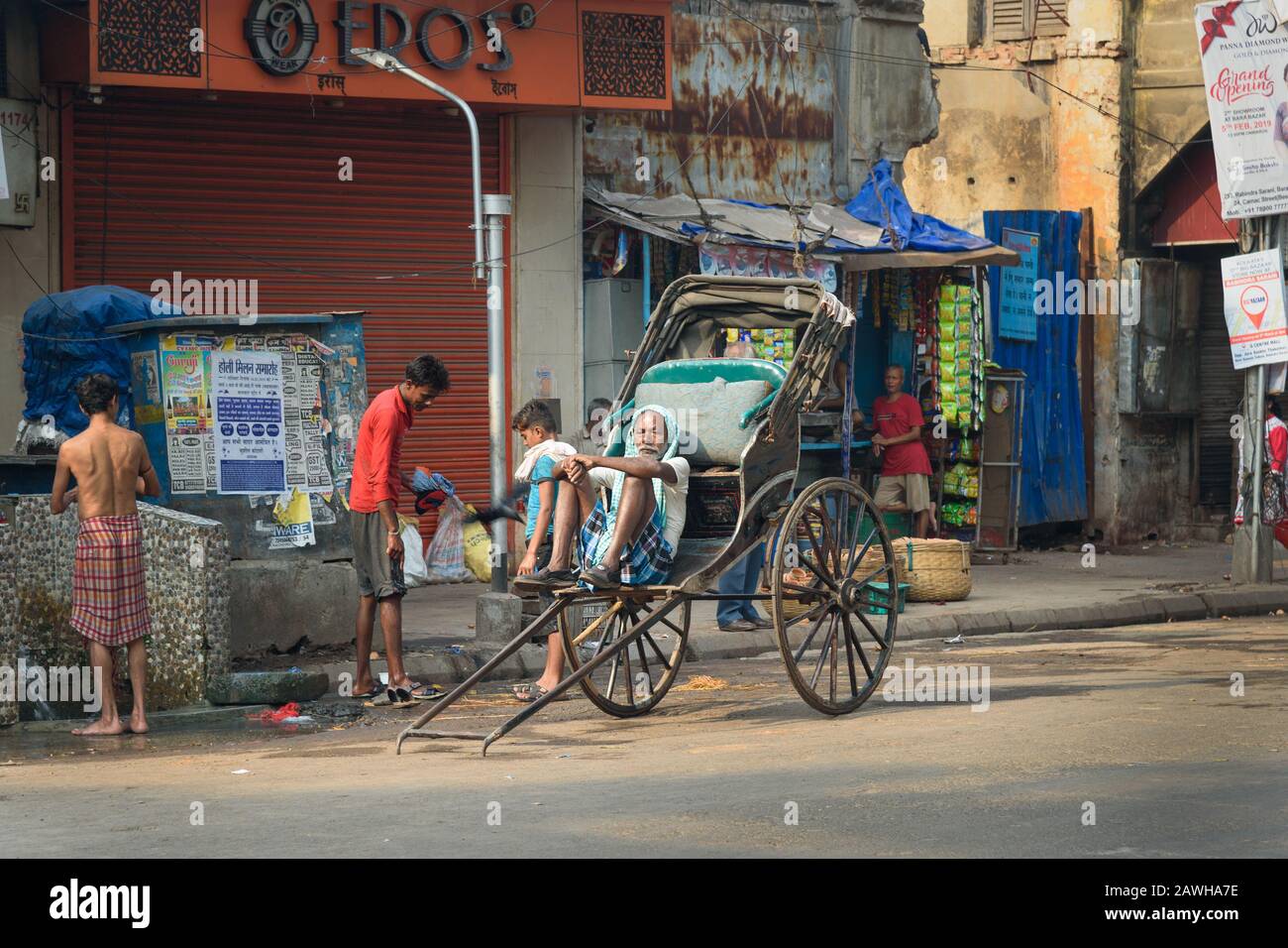 Indian rickshaw puller sitting on his rickshaw and waiting for ...