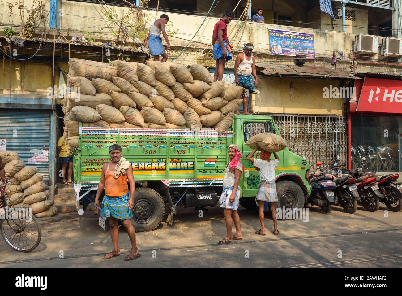 Workers loading cargo bags in truck on the street in Kolkata. India ...