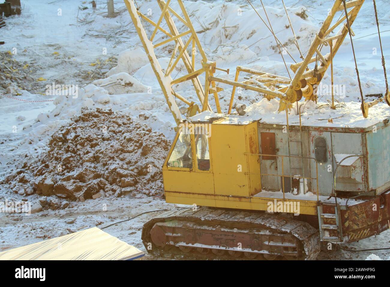 Large crawler crane works at a construction site on a frosty sunny day ...