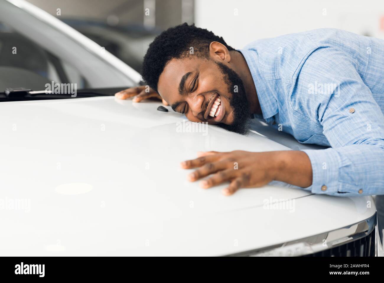 Happy African American Man Hugging New Car In Auto Dealership Stock ...