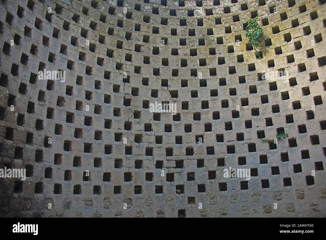Round stone wall with many holes on an even distance Stock Photo - Alamy