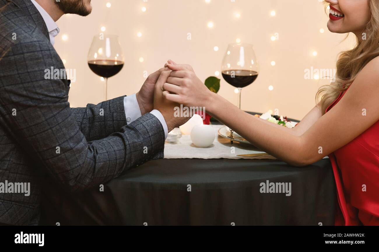 Closeup Of Couple Holding Hands In Restaurant, Having Romantic Date ...