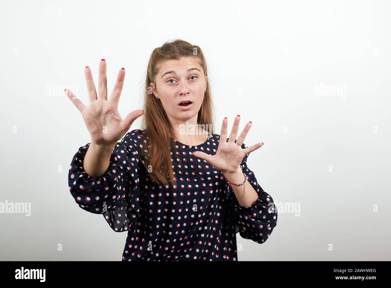 girl frightened woman makes stop sign out of fear holding the palms of ...