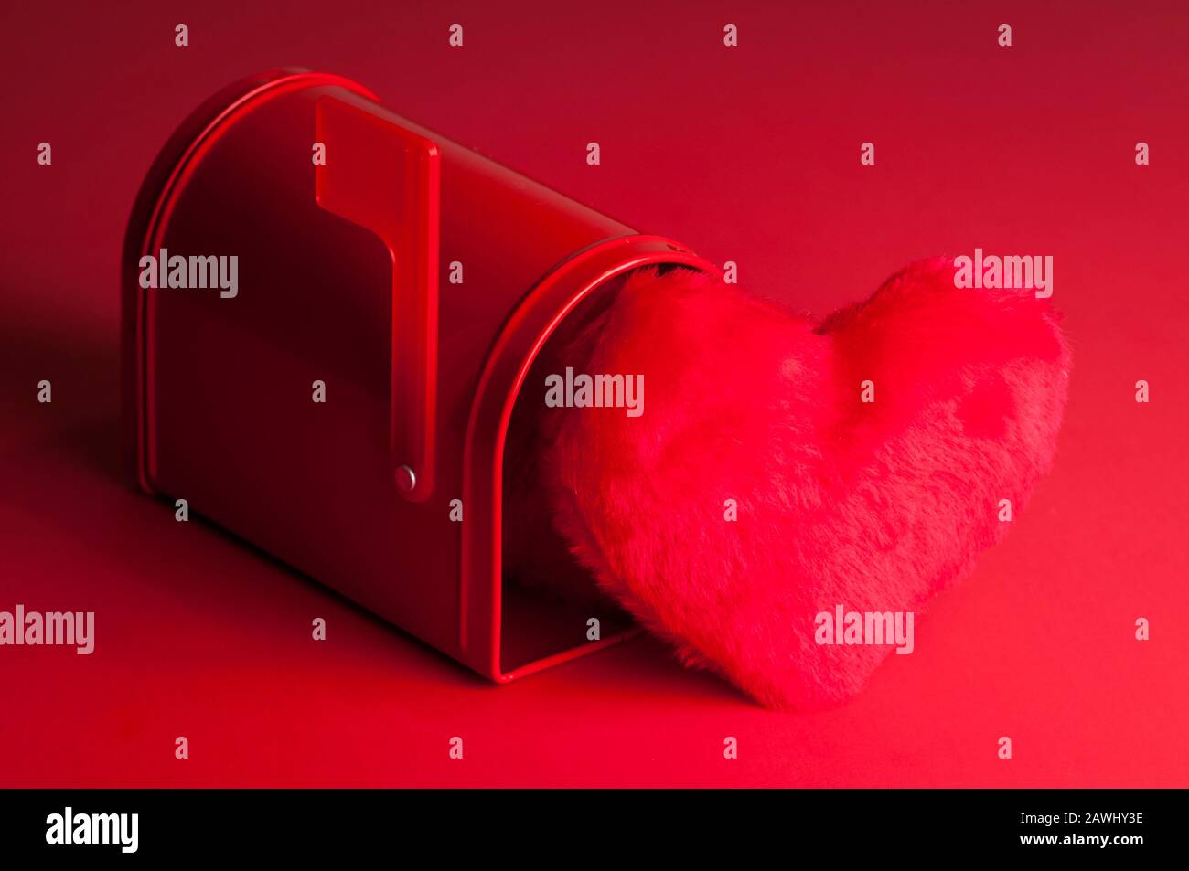 Fuzzy Valentine's Day love heart emerging from simple mailbox on red ...