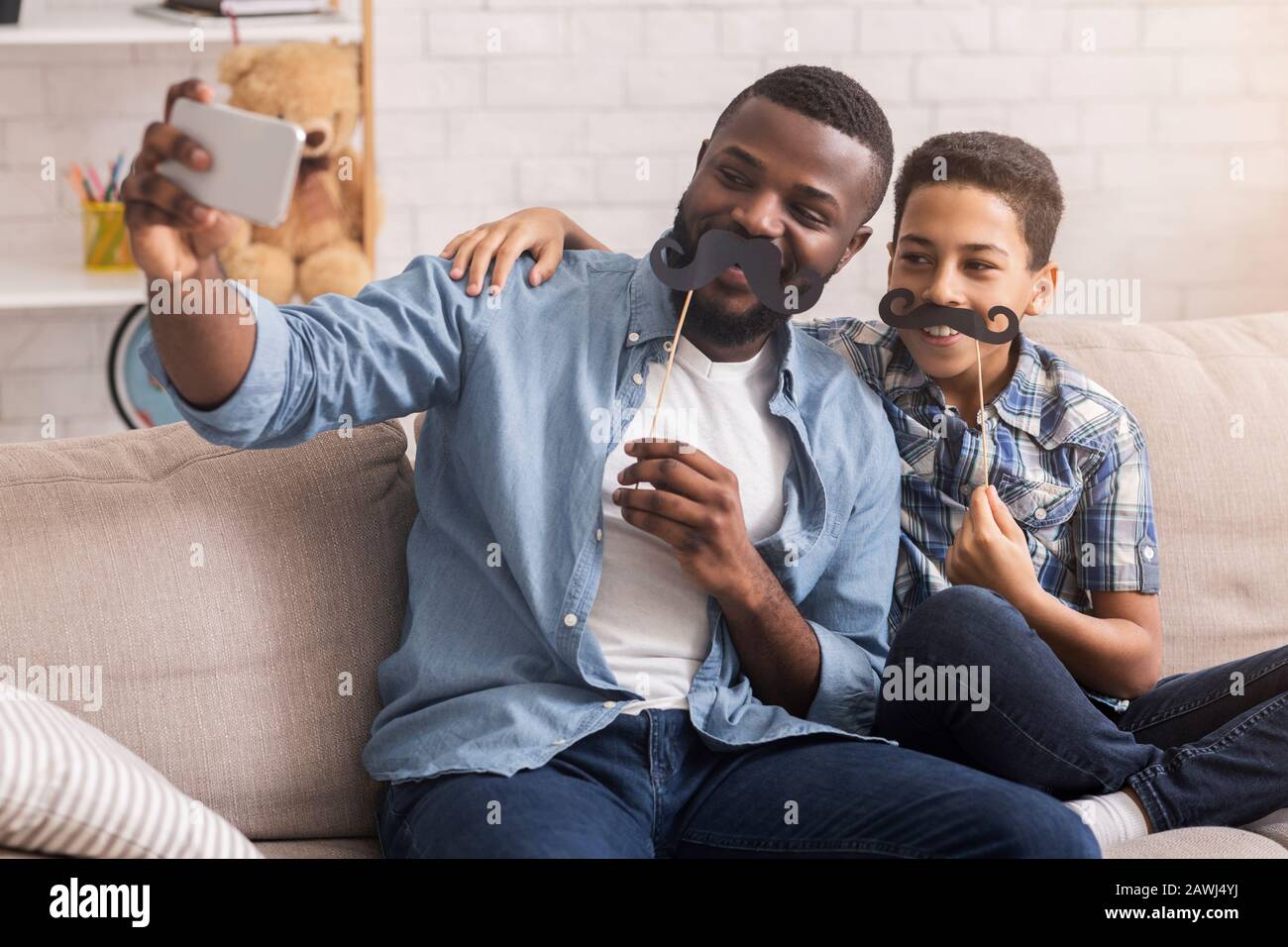 Joyful black father and son posing for selfie at home Stock Photo - Alamy